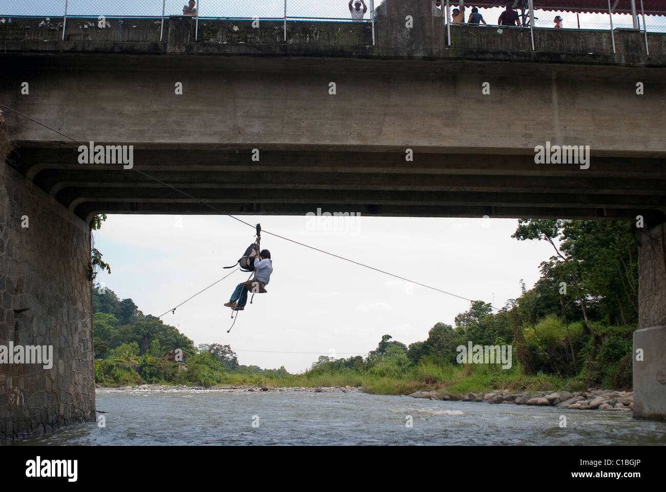 A primitive zip line with a wooden seat serves to move people and ...