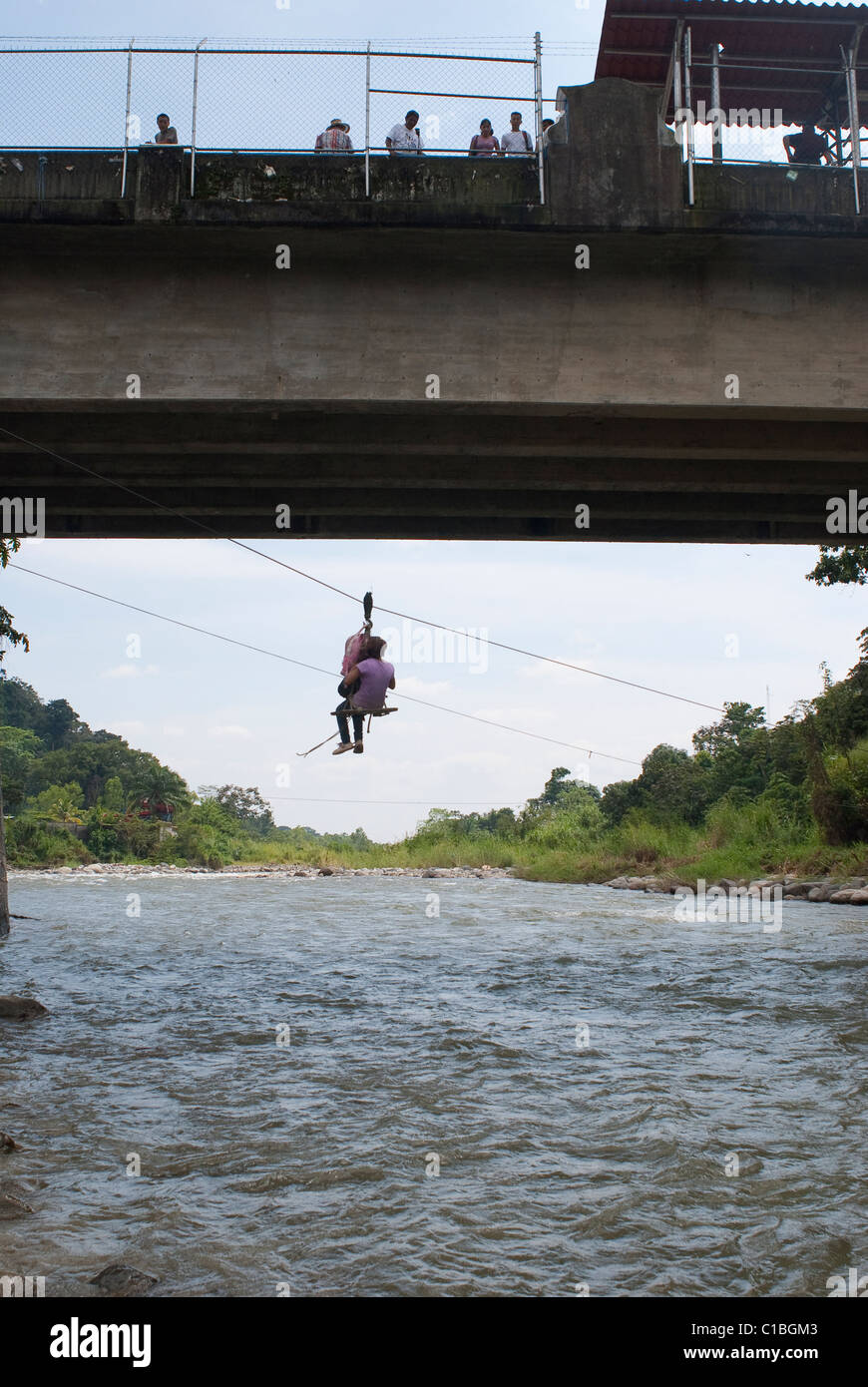 A primitive zip line with a wooden seat serves to move people and ...