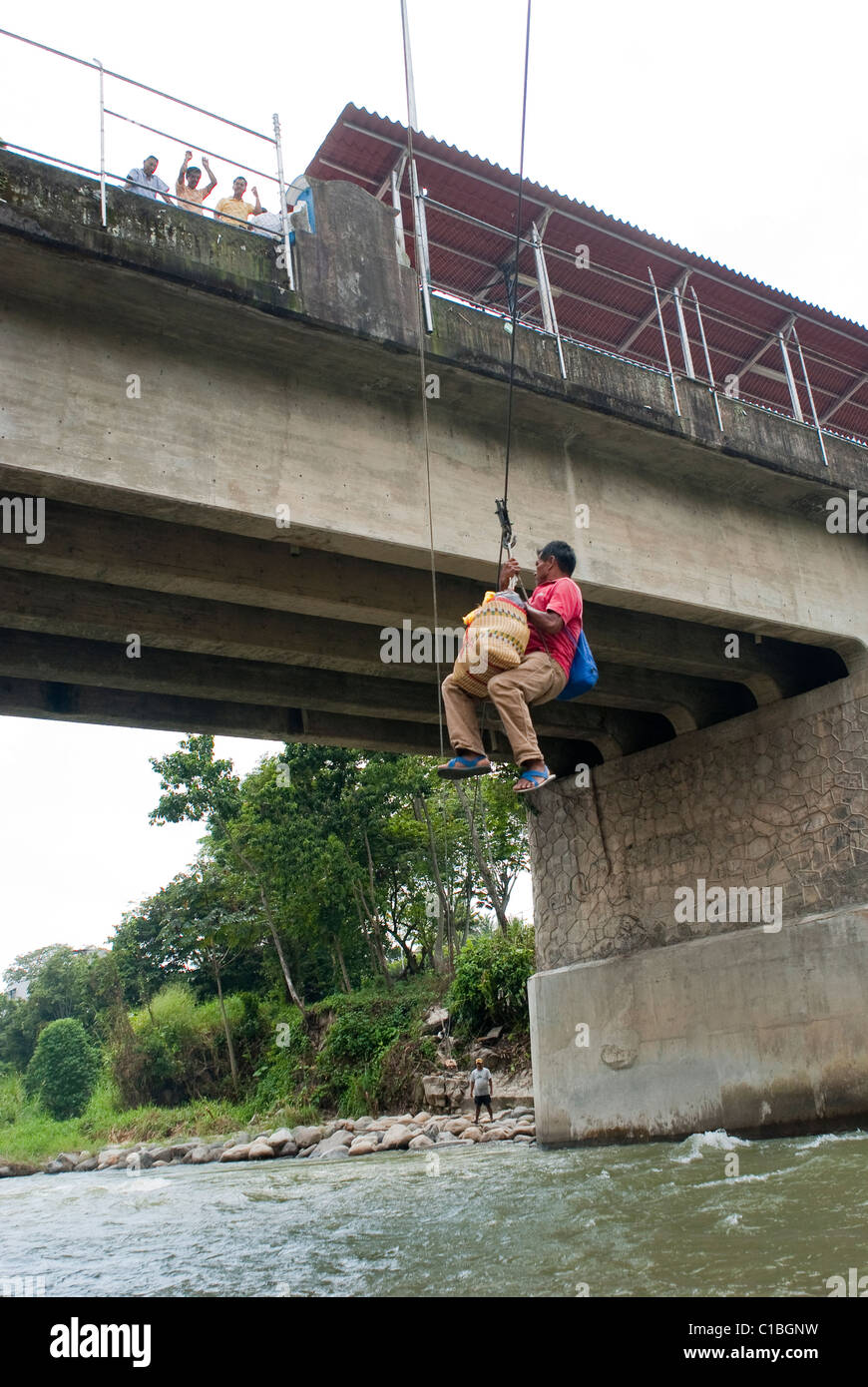 A primitive zip line with a wooden seat serves to move people and ...