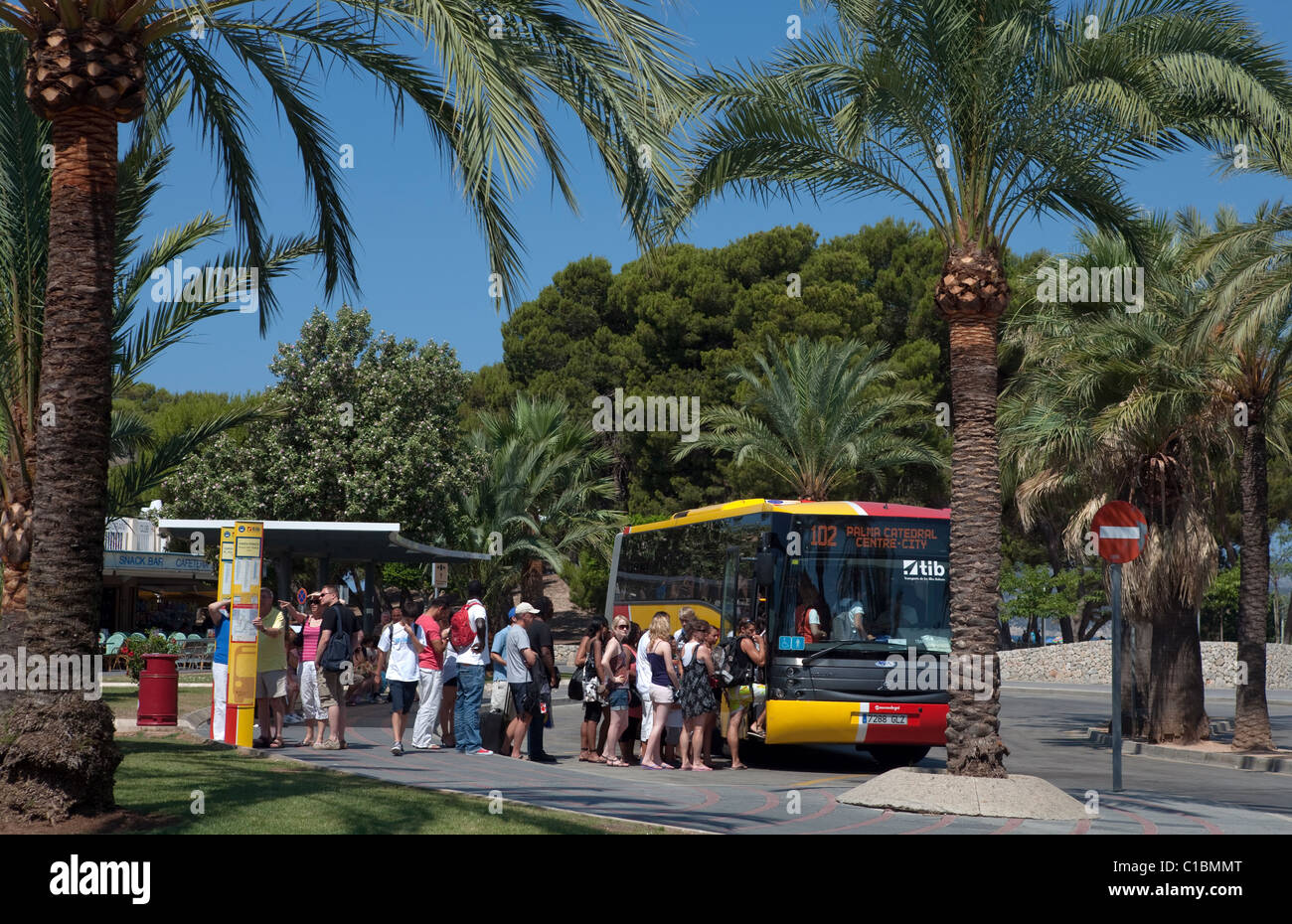 Group of tourists in row at bus stop climbing on the bus Mallorca ...