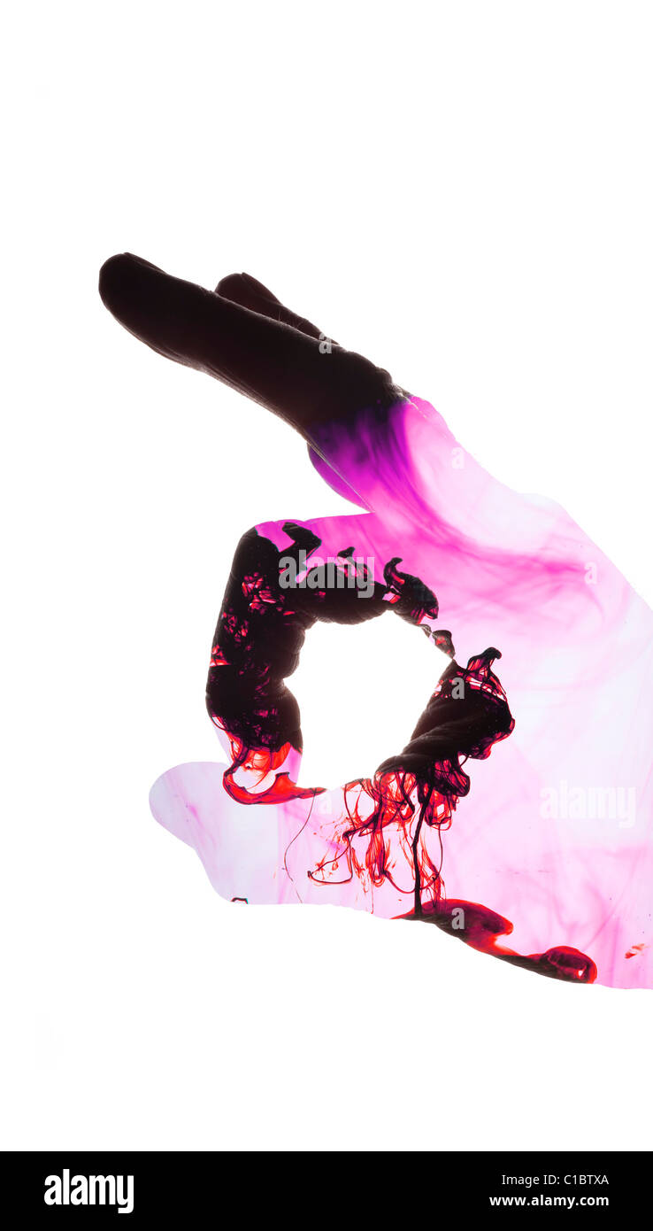 Hand making OK with sign language with swirling orange liquid colours ...