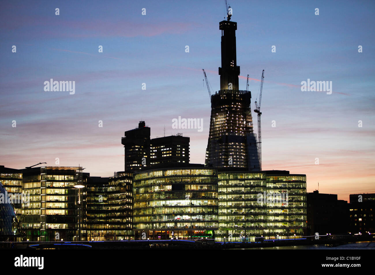 Office buildings at More London lit up at night in front of The Shard ...