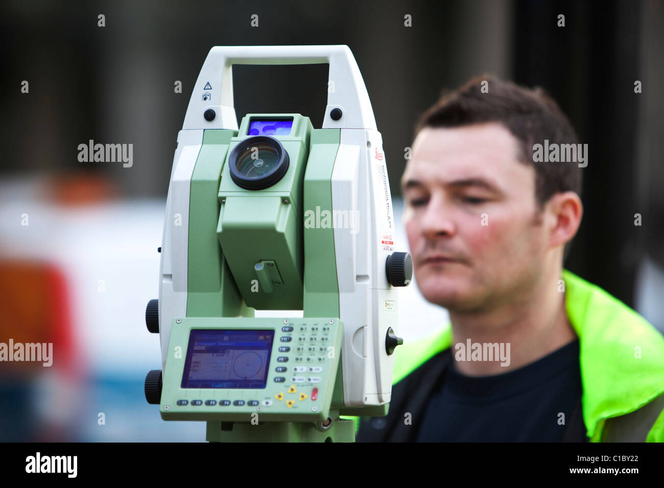 Surveyor operating a theodolite. A theodolite is a precision instrument ...