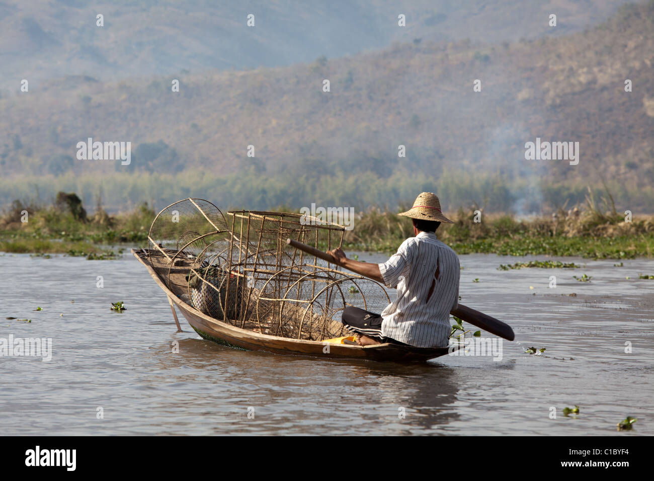 Tribal people on Inle lake are daily paddling their floating boats from ...