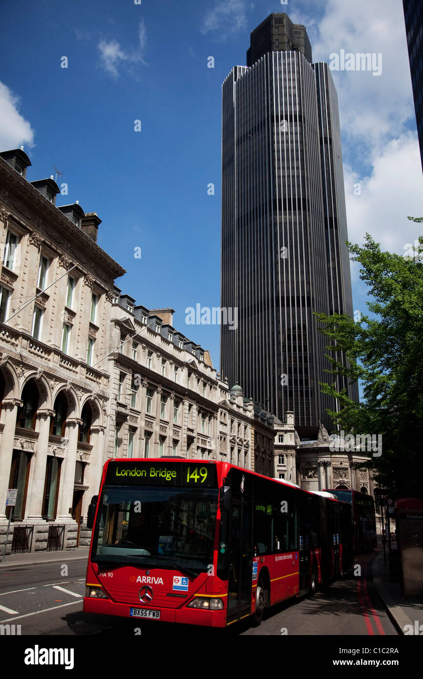 Bendy bus passes Tower 42 in the City of London. Once known as the Nat ...