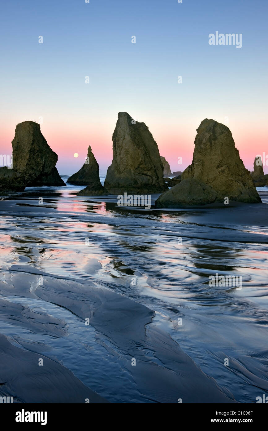 Moon sets as sunrise color bathes the many sea stacks at Oregon's ...