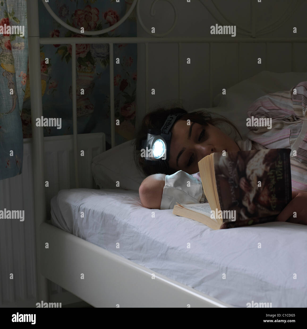Reading book with head torch Stock Photo - Alamy
