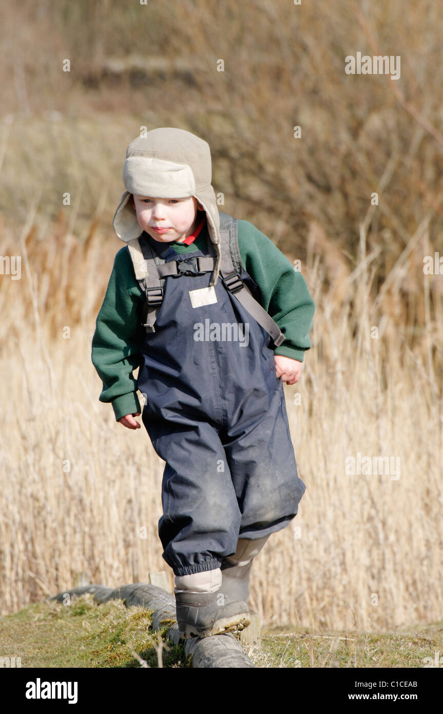 A young boy balancing along a log beside a path Stock Photo - Alamy
