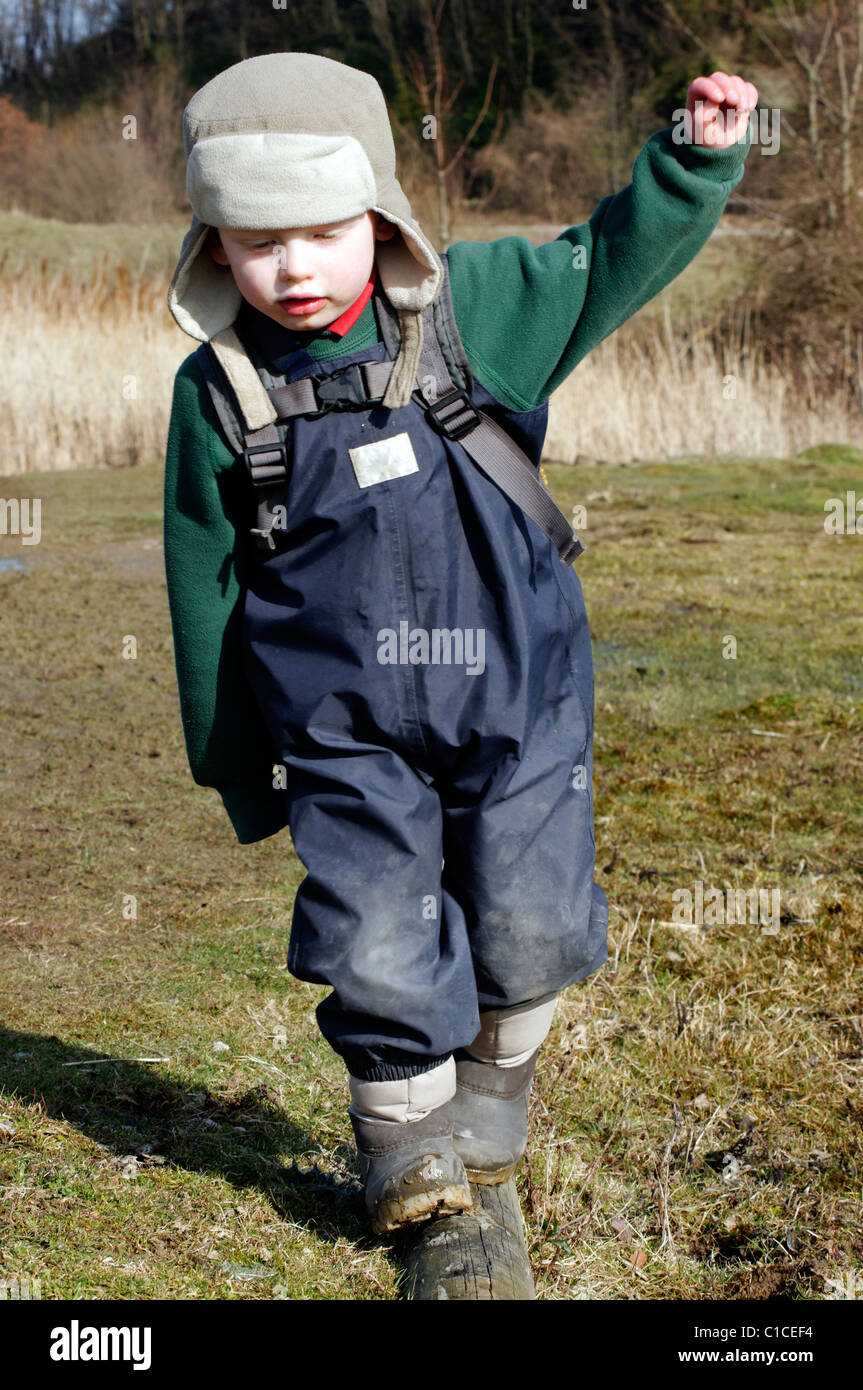 A young boy balancing along a log beside a path Stock Photo - Alamy