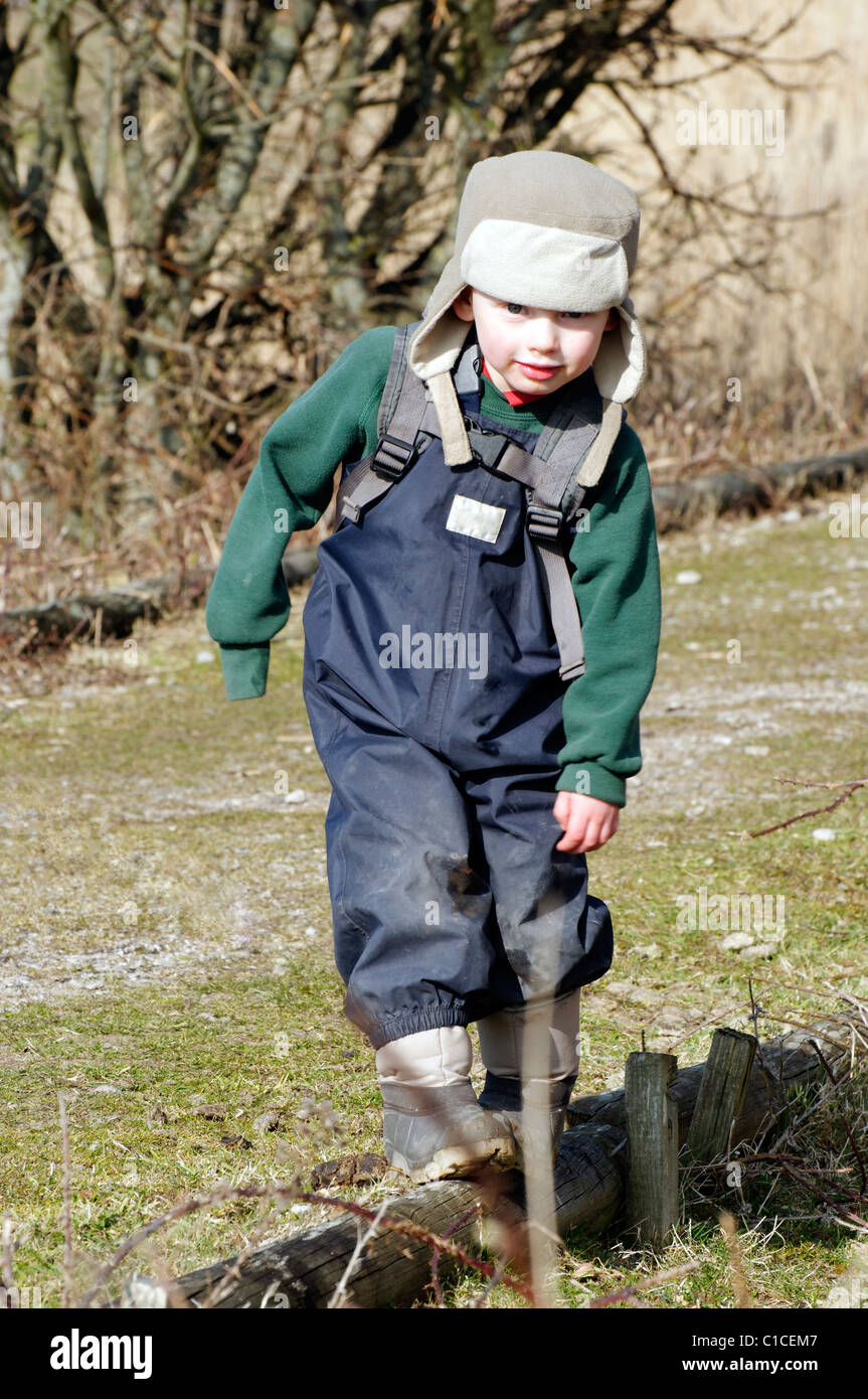 A young boy balancing along a log beside a path Stock Photo - Alamy
