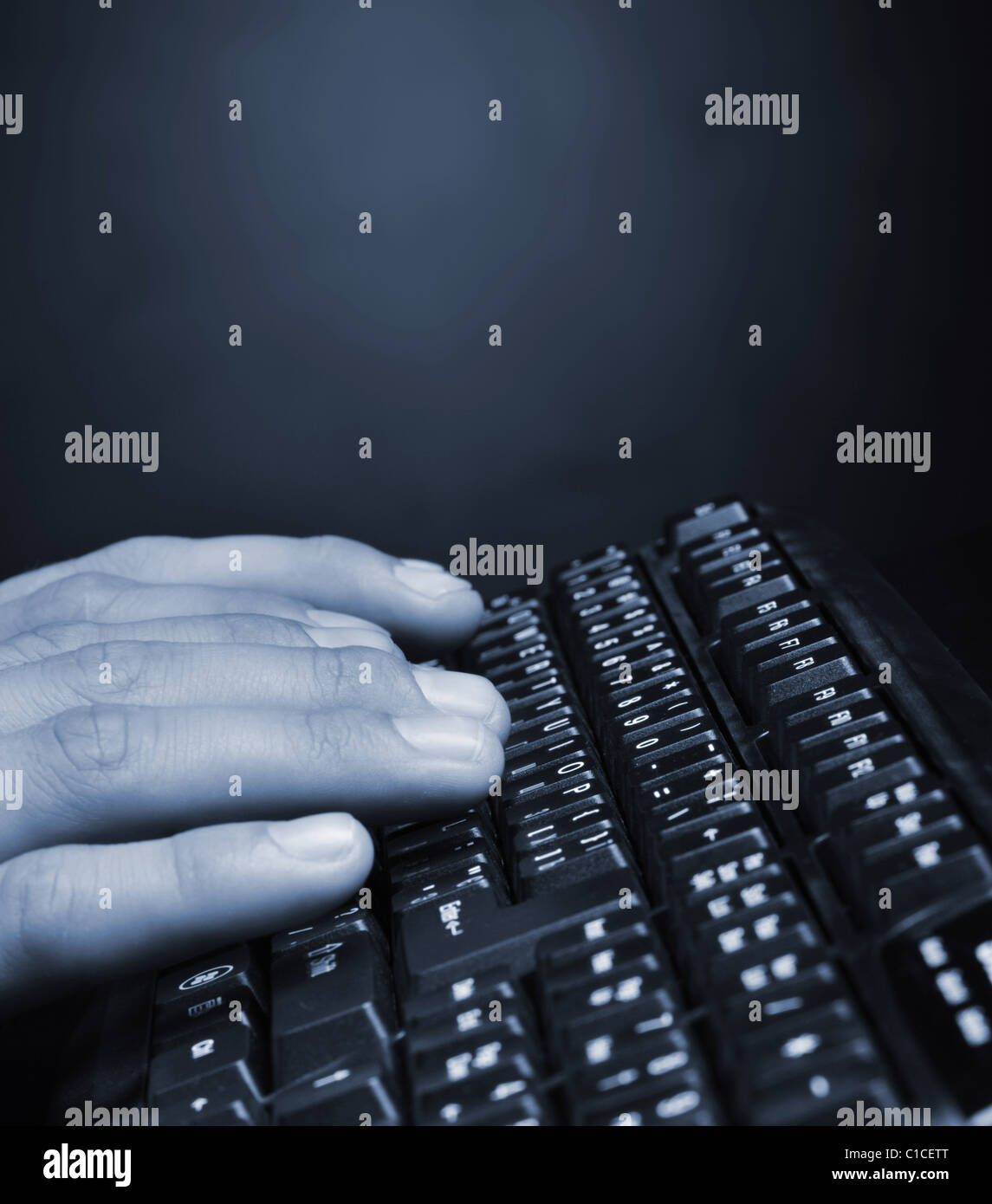 Hands above the keyboard. On a dark background, the black keyboard ...