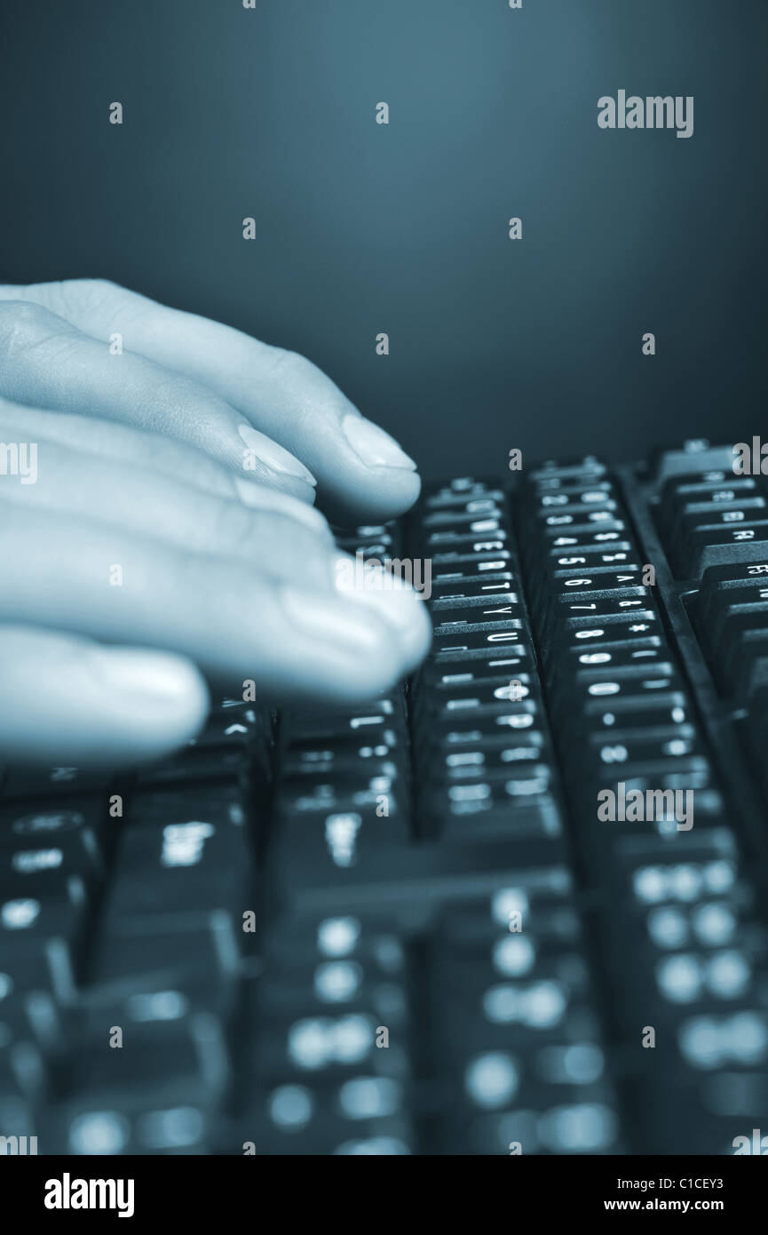 Hands above the keyboard. On a dark background, the black keyboard ...