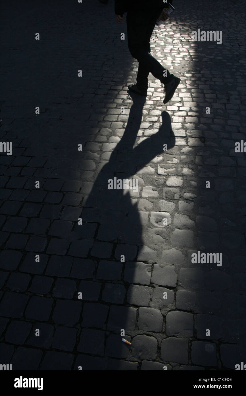 person shadow feet legs walking on cobbles in street in town Stock ...