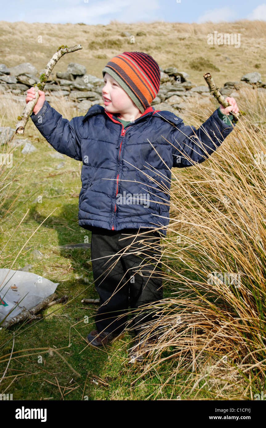 A young boy breaking up and collecting kindling Stock Photo - Alamy
