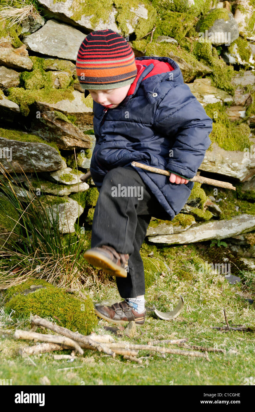 A young boy breaking up and collecting kindling Stock Photo - Alamy