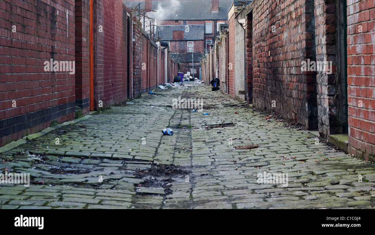 Household rubbish left lying about in a dirty back street cobble stoned ...