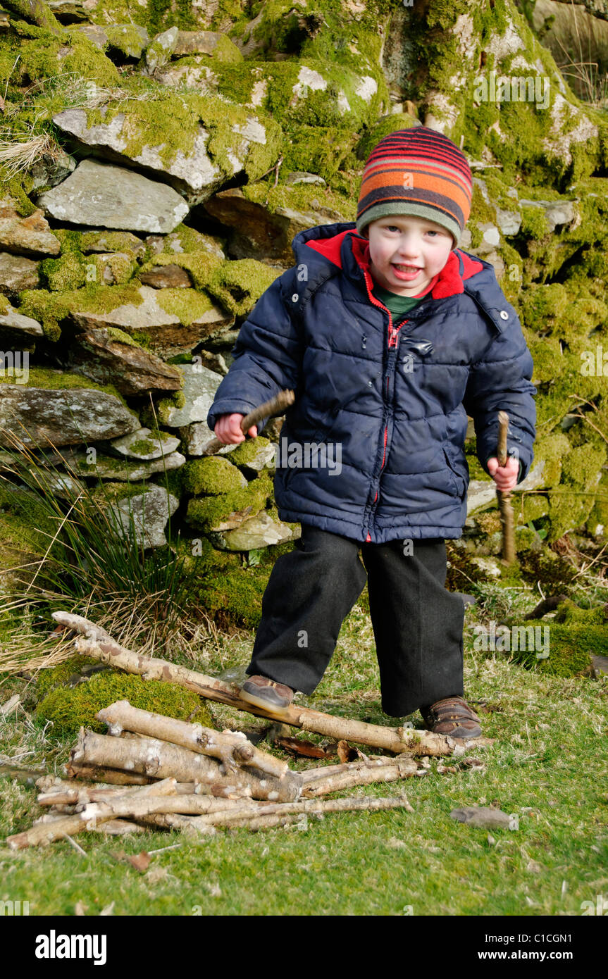 A young boy breaking up and collecting kindling Stock Photo - Alamy