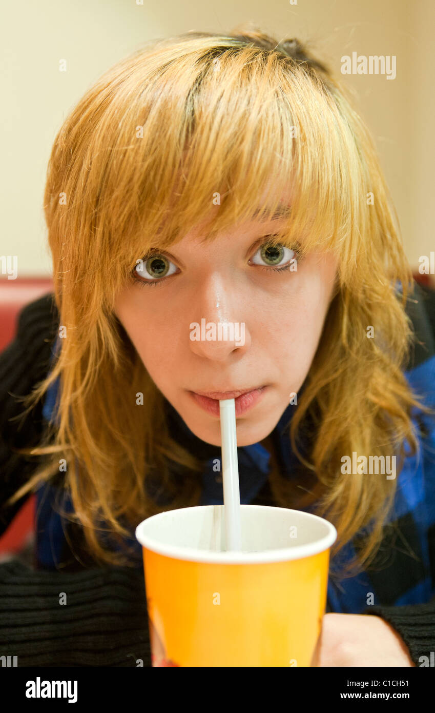 Teenager sipping a drink through a straw Stock Photo - Alamy
