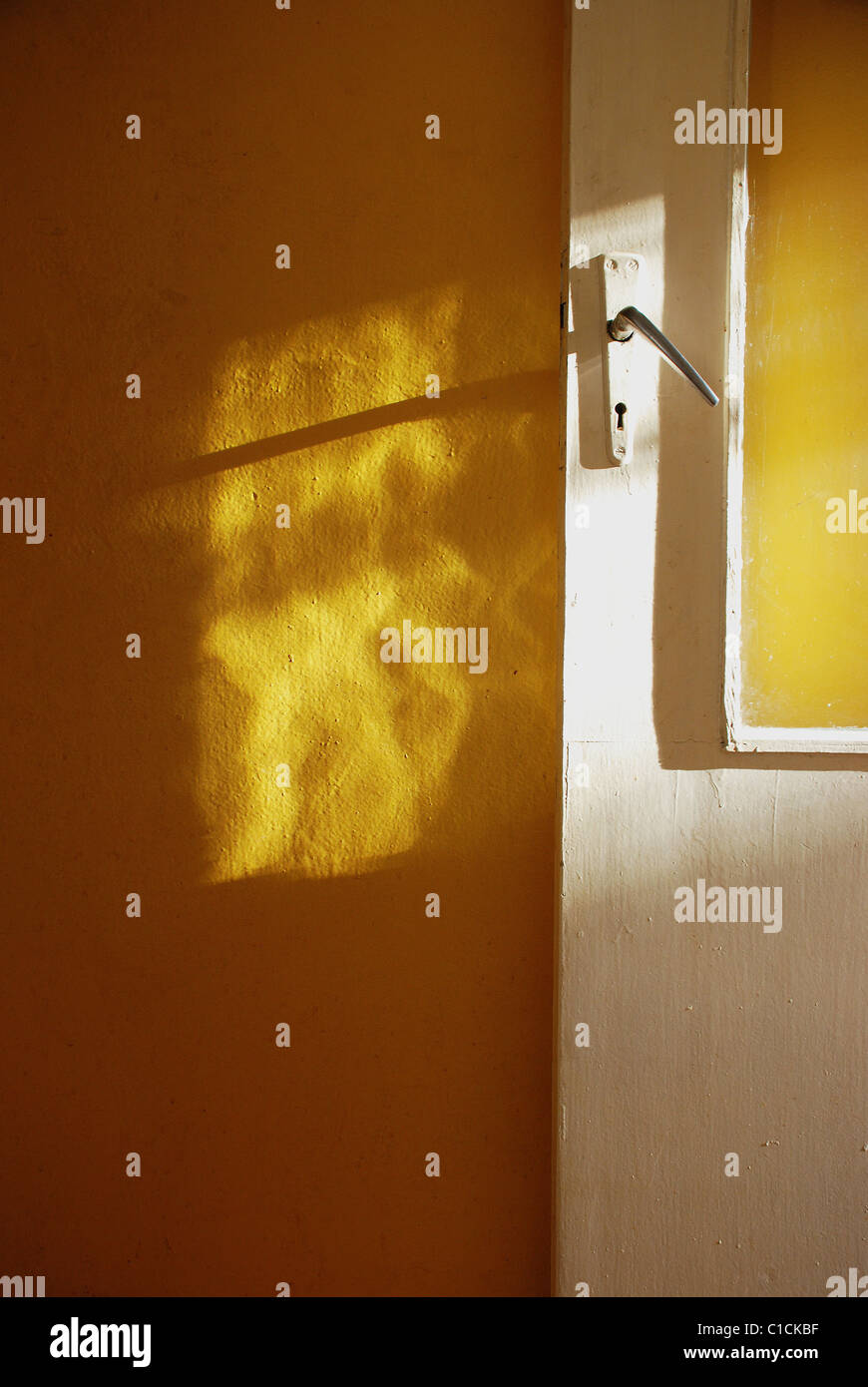 White door and the sun's reflection on a yellow wall Stock Photo - Alamy