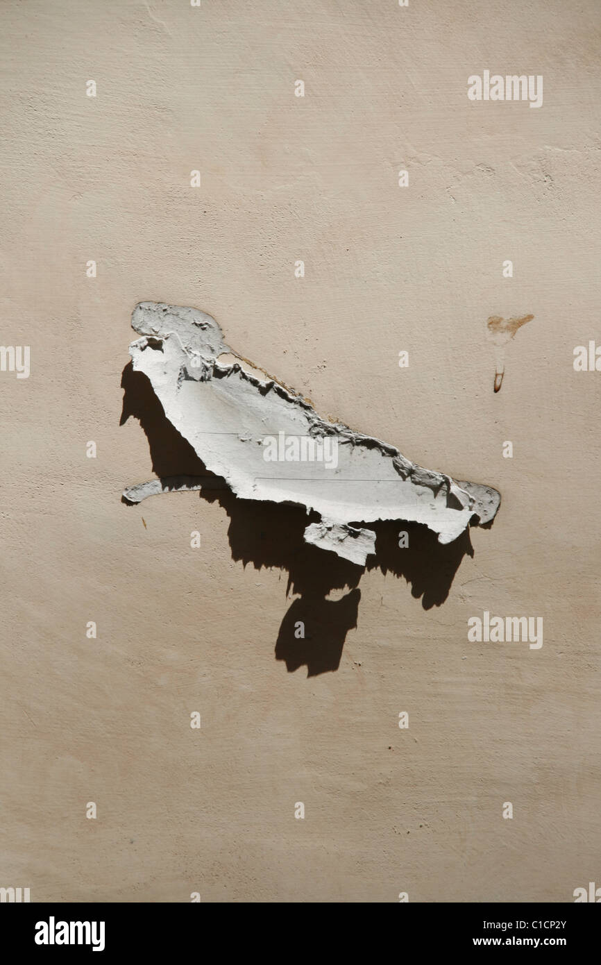 torn sheet of paper stuck to wall in city town Stock Photo - Alamy