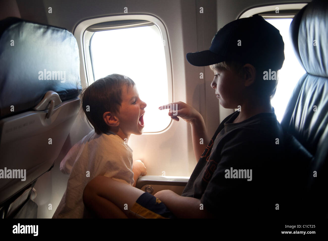 Two brothers playing on a plane during a long flight to visit their ...