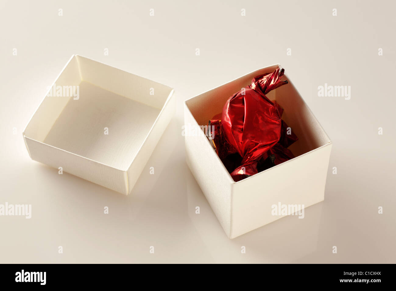 Small white gift box open showing chocolate sweets inside Stock Photo ...