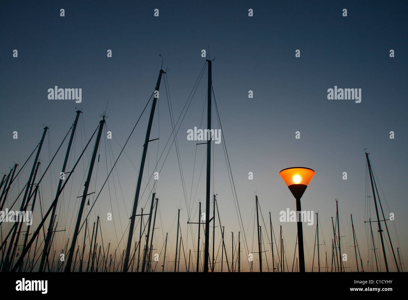 boats masts and street light in port dock at night Stock Photo - Alamy
