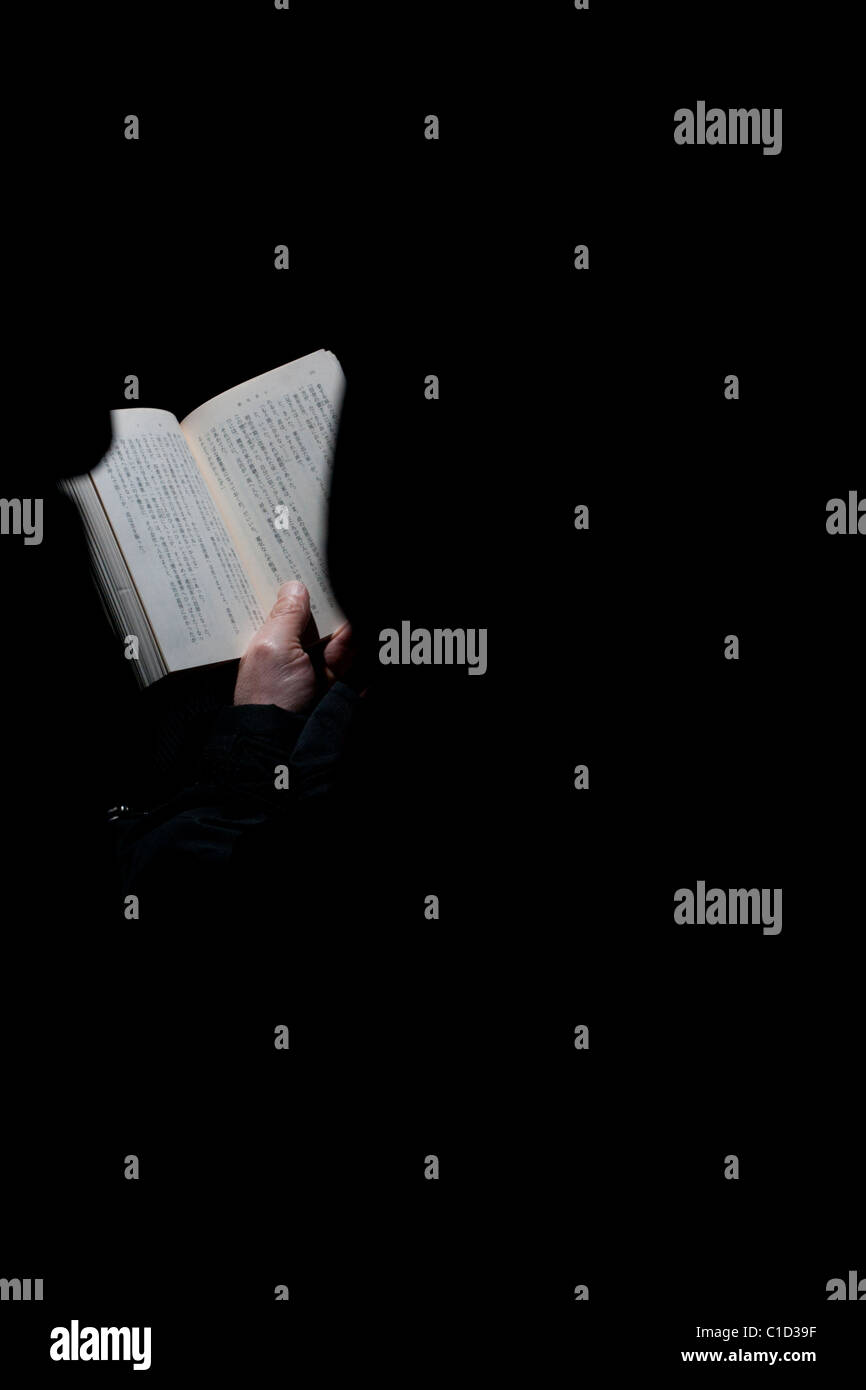 A Japanese man pictured reading a Japanese book on a flight to Japan ...