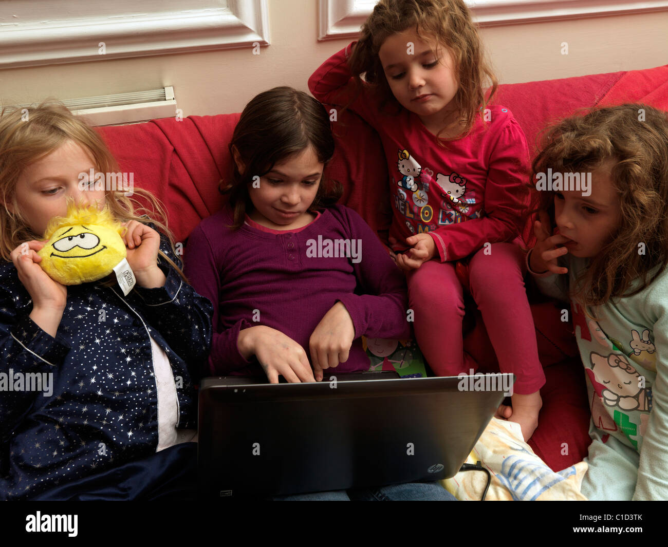Girls Playing Computer Game On A Laptop In The Living Room Stock Photo ...