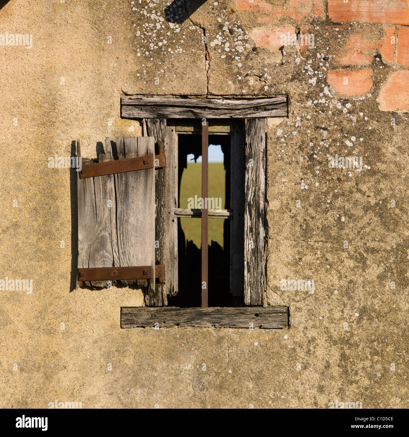 Weathered wooden window frame set in a rustic stone wall revealing a ...