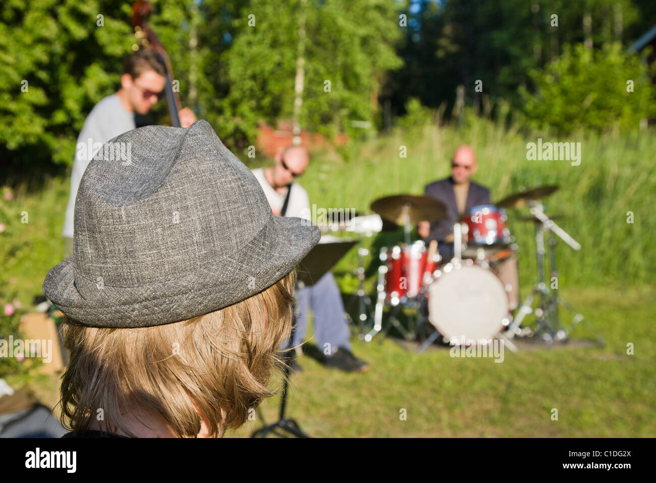 Young man watching jazz band playing Stock Photo - Alamy