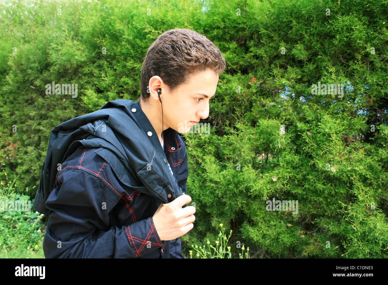 Teen with ear-phone looking down Stock Photo - Alamy