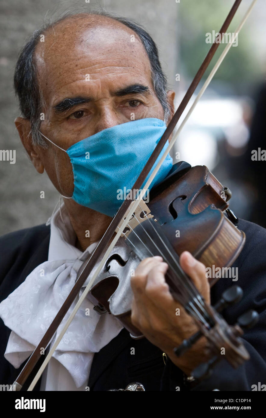 A Mexican busker wearing a mask plays the violin in Mexico City ...