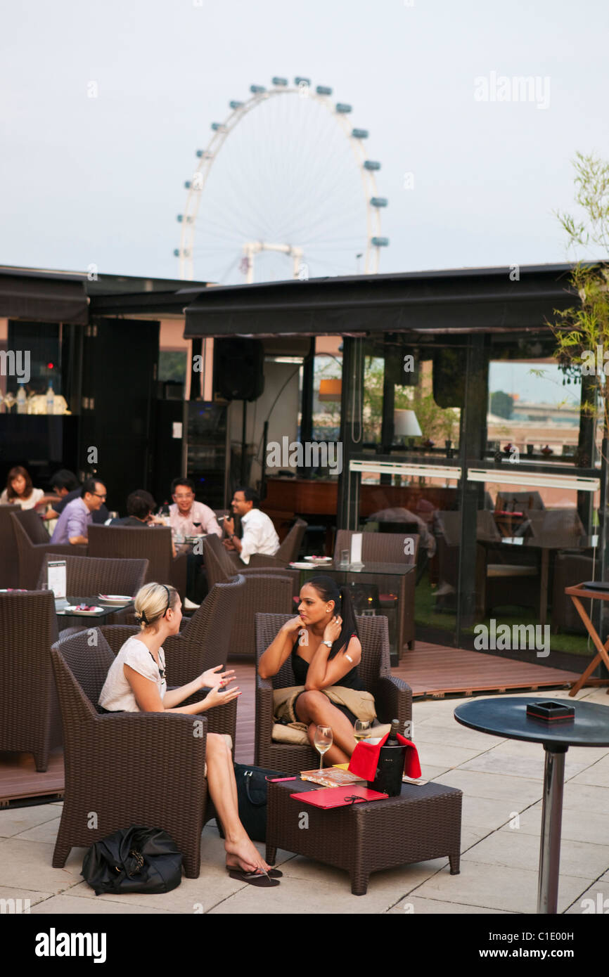 Women drinking at Orgo Bar & Restaurant with Singapore Flyer in ...