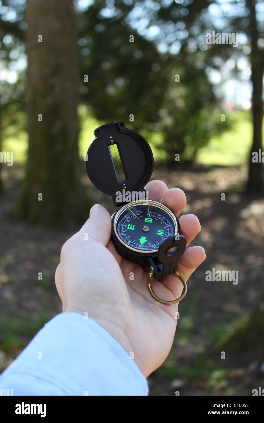 Male hand holding compass in forest, vertical orientation Stock Photo ...