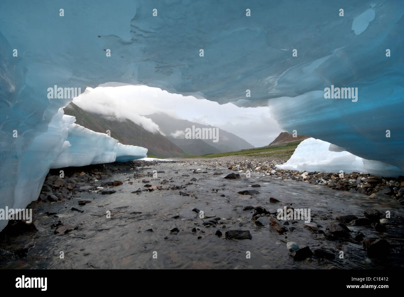 Intricate blue ice arch over glacier river. Valley of river Eheger ...