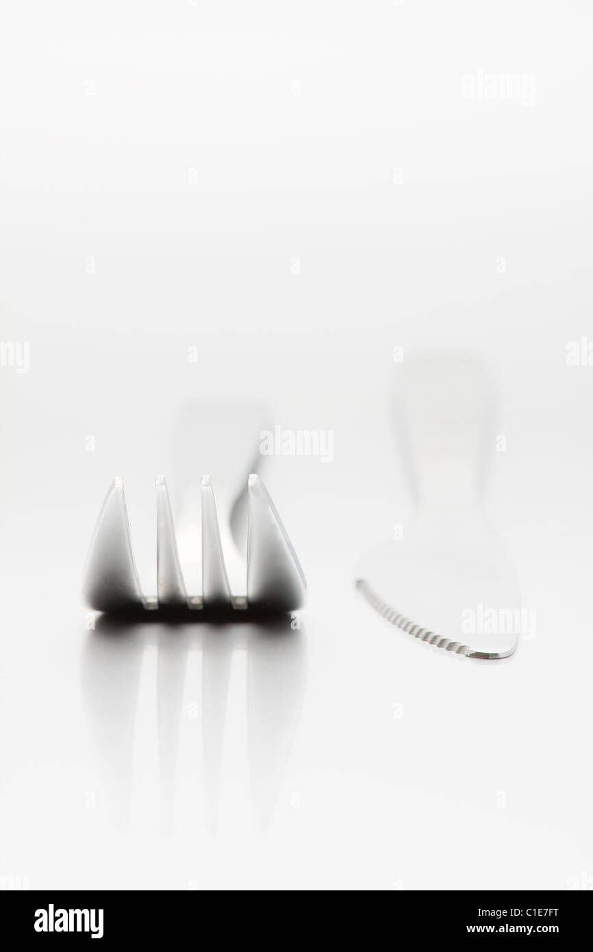 Fork and knife with reflection on metallic background Stock Photo - Alamy