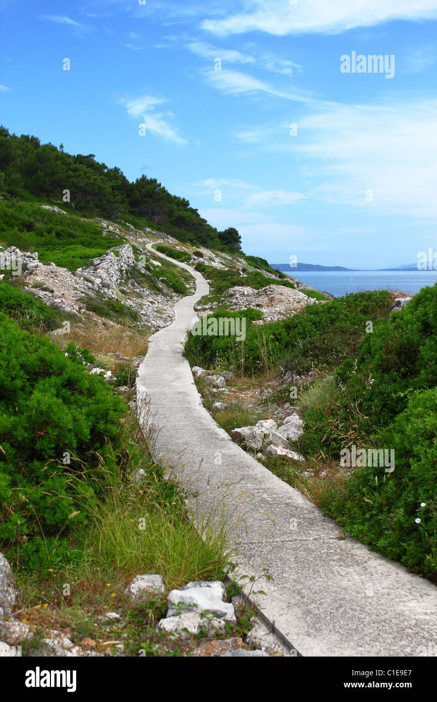 Paved walkway winding through rocky Mediterranean landscape near the ...