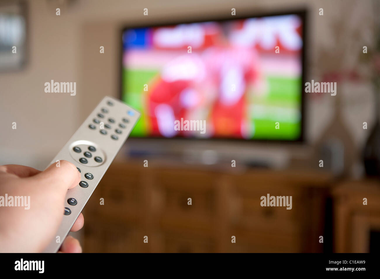 Watching television with remote control Stock Photo - Alamy