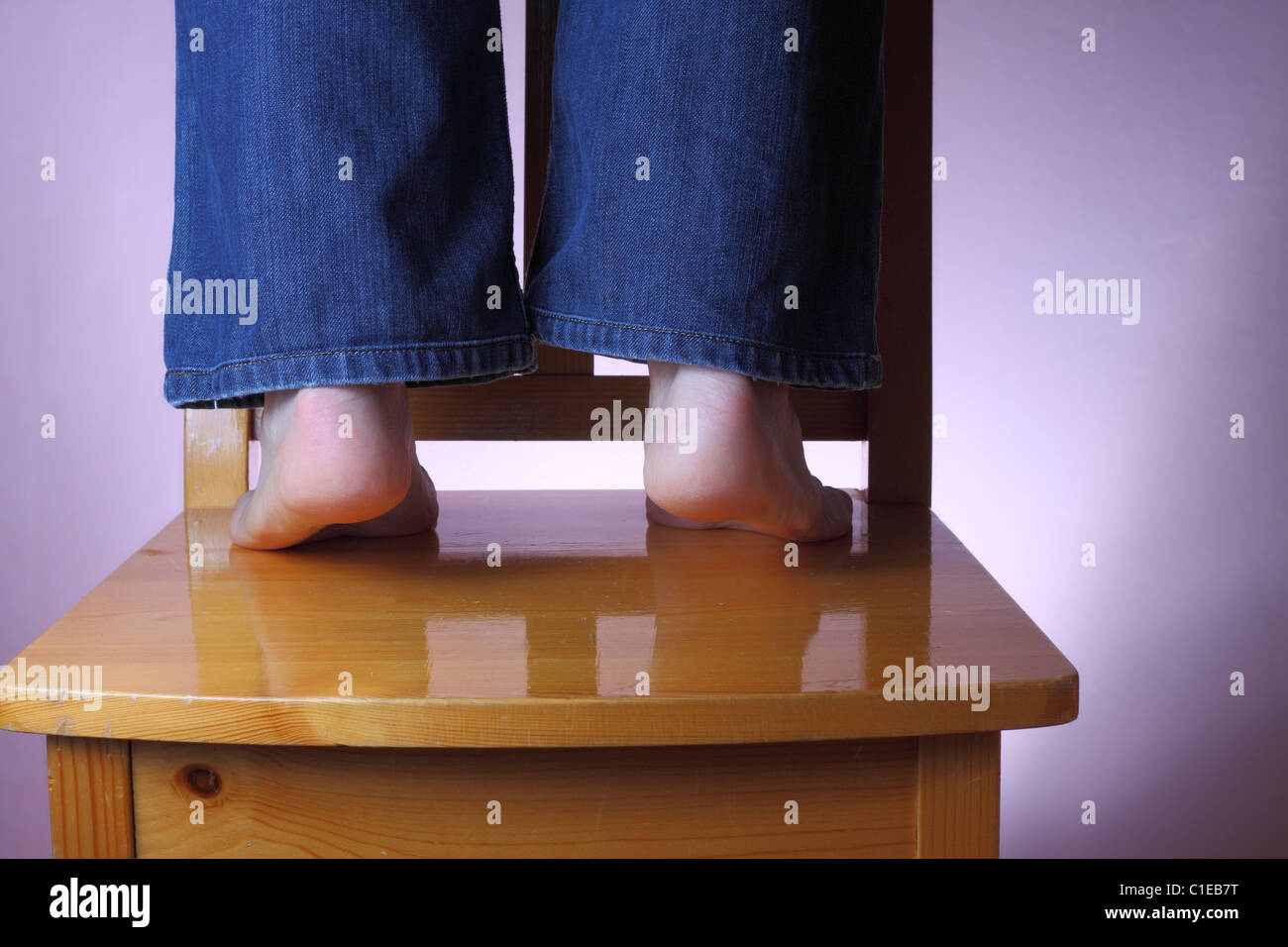 Man standing feet on chair hi-res stock photography and images - Alamy