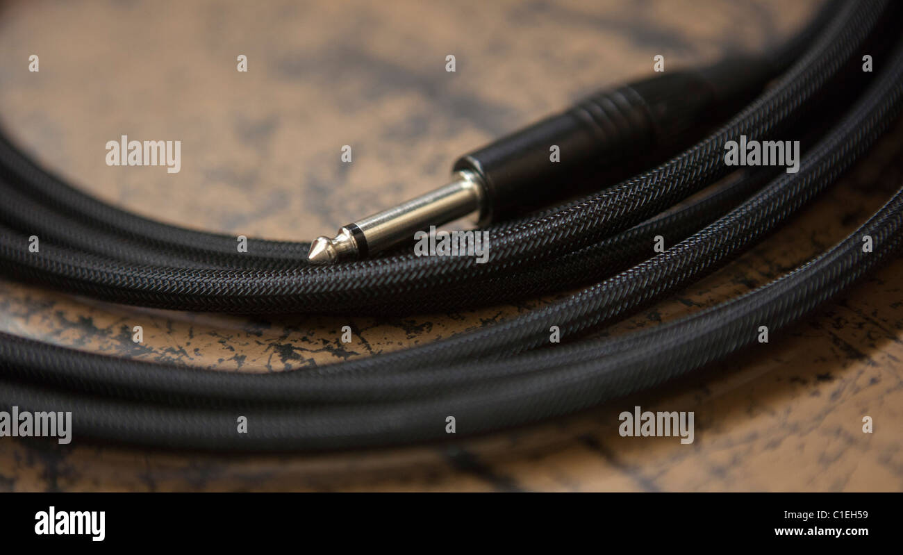 Guitar cable with quarter inch connector, coiled on a workbench Stock ...
