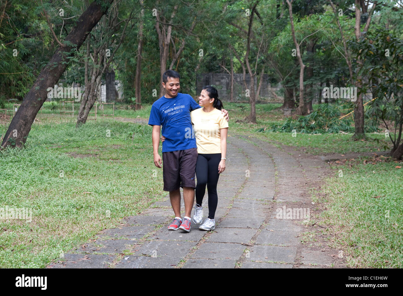 couple wearing sporty attire walking in a park Stock Photo - Alamy