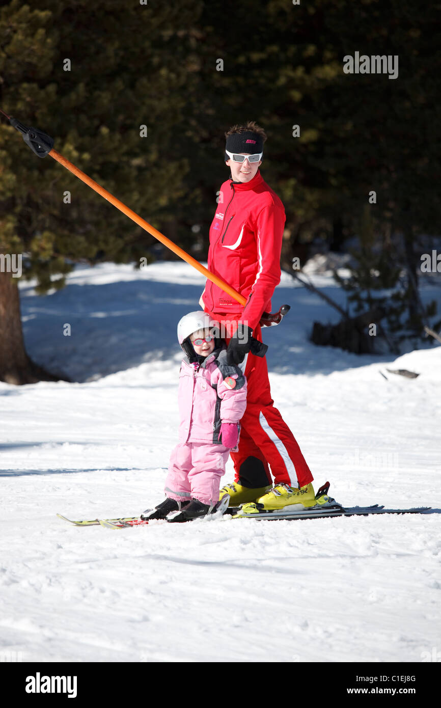 skiing teacher with child on ski tow Stock Photo - Alamy