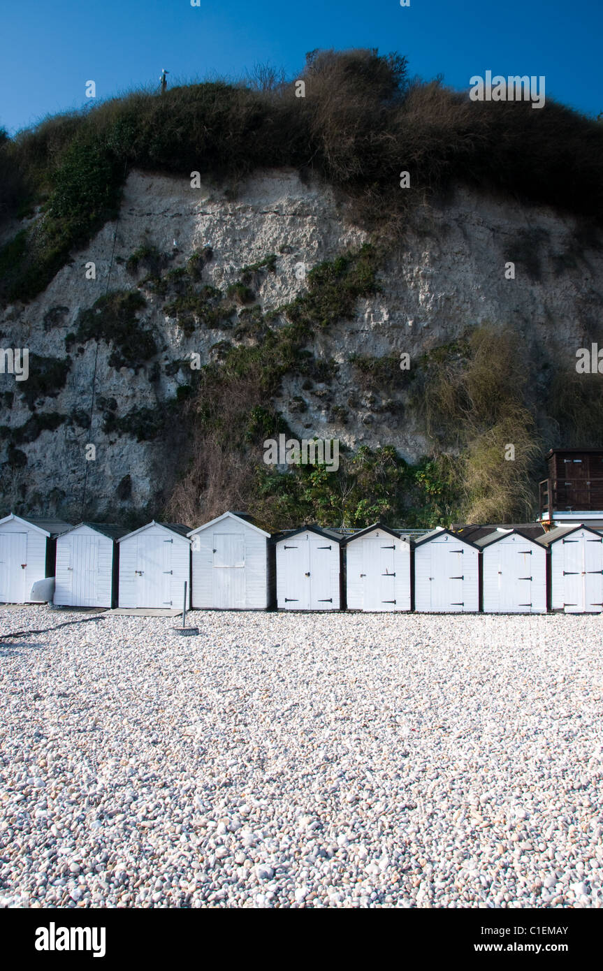 Wooden beach huts and cliffs on the beach at Beer in Devon, England, UK ...
