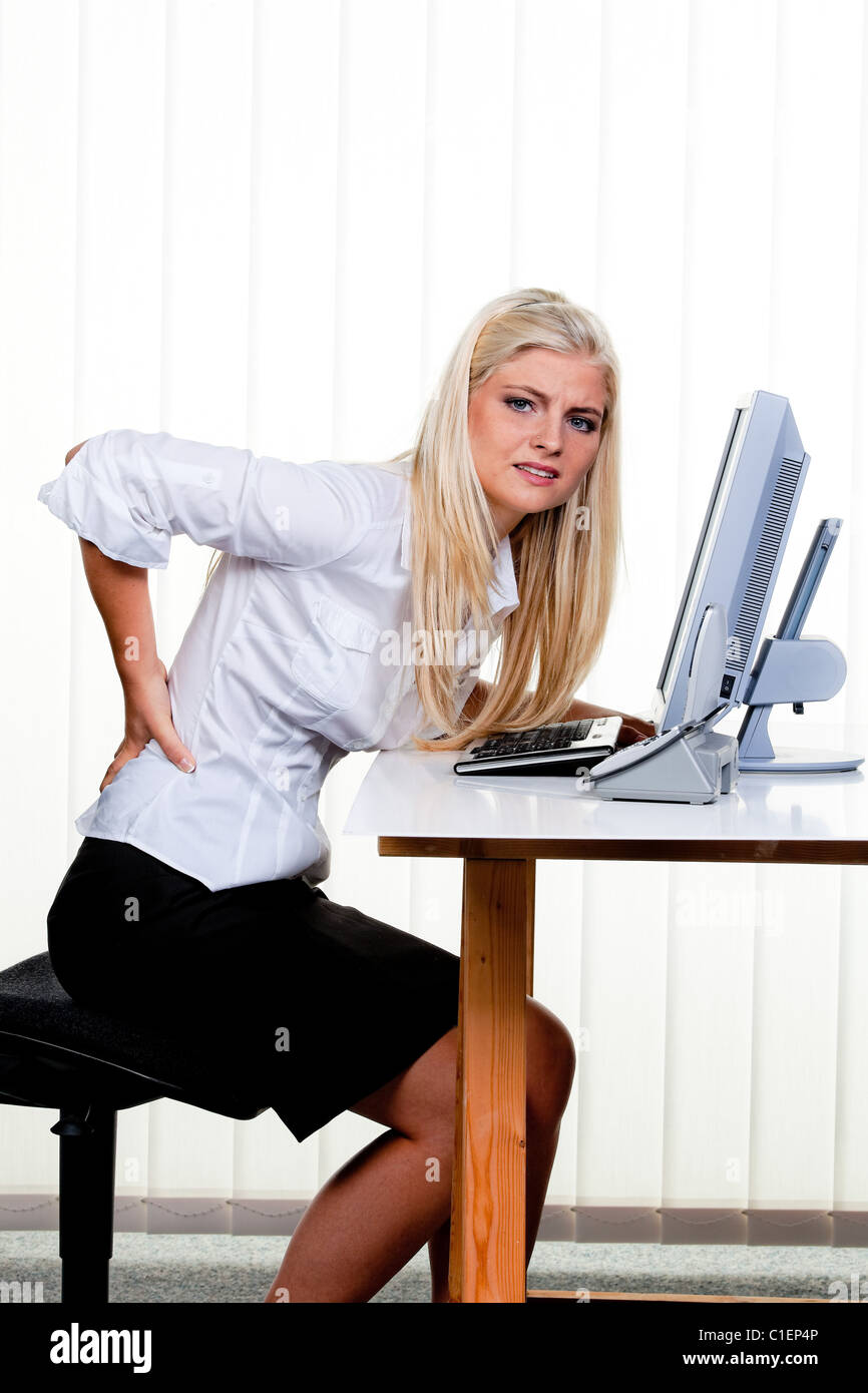 young woman with aching back in office Stock Photo - Alamy