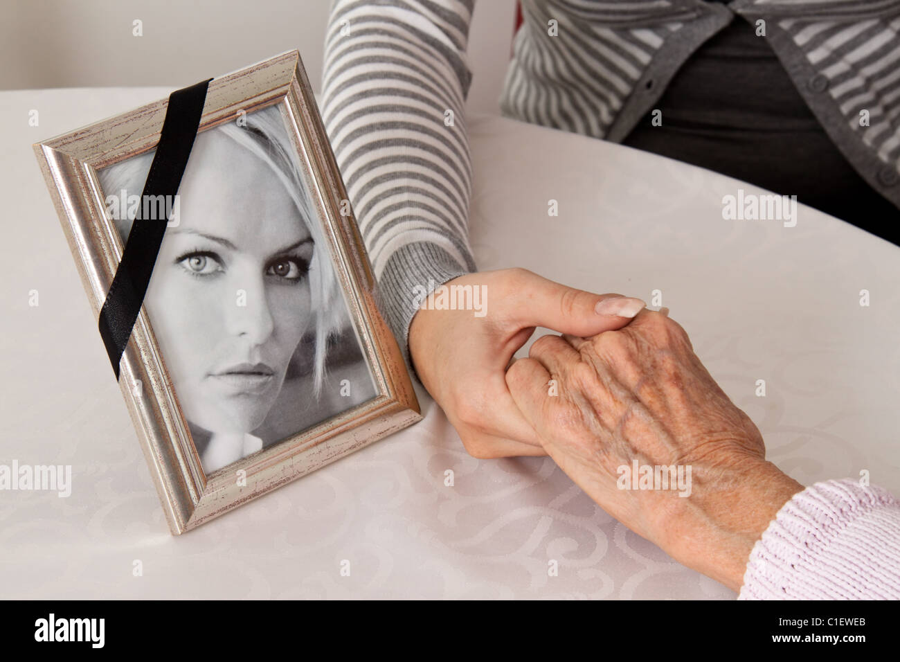 Holding hands for comfort. Grief at death Stock Photo - Alamy