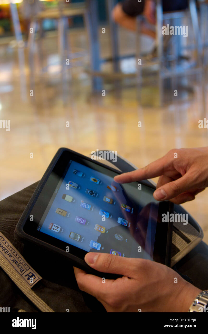 man tapping the ipad tablet in the public Stock Photo - Alamy