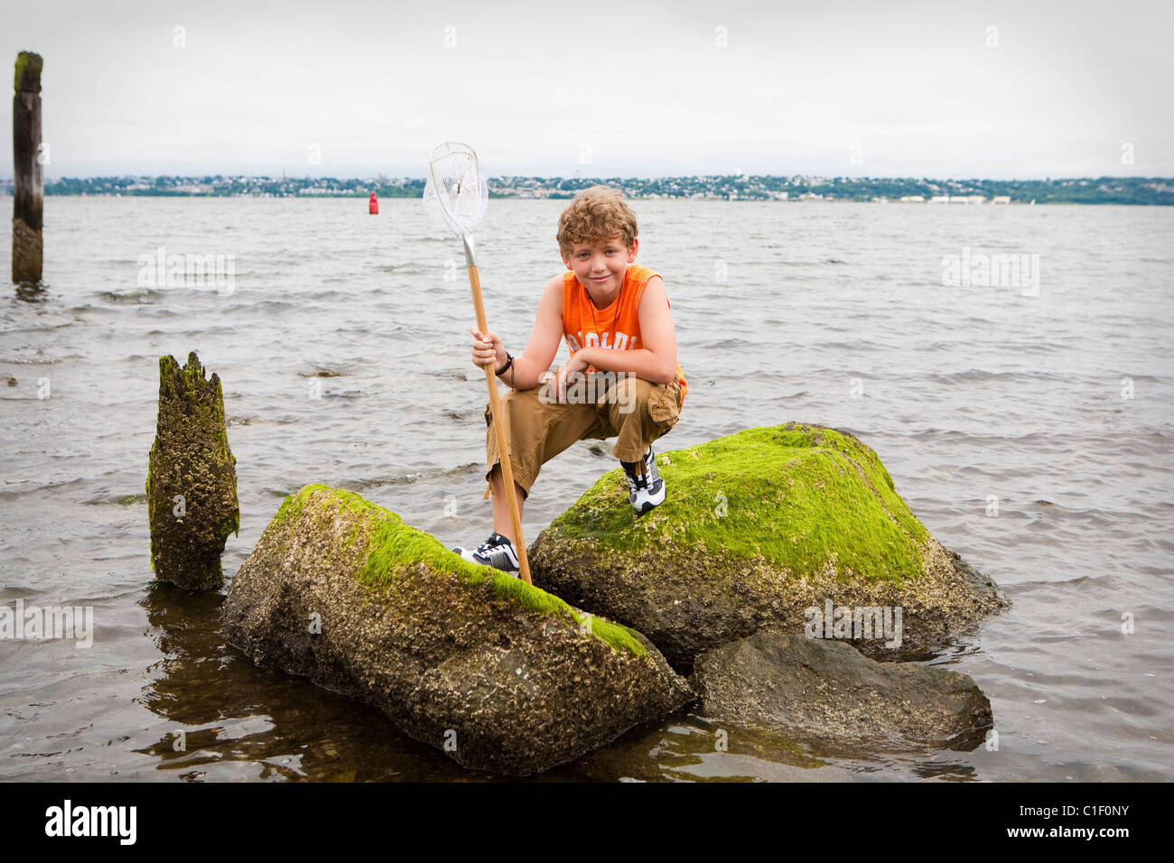 Child crouching on rock hi-res stock photography and images - Alamy