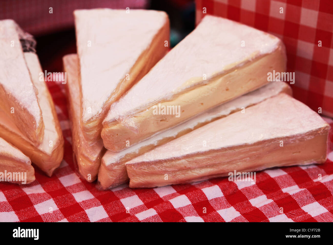 Pieces of soft French cheese are wrapped and ready for sale at a ...