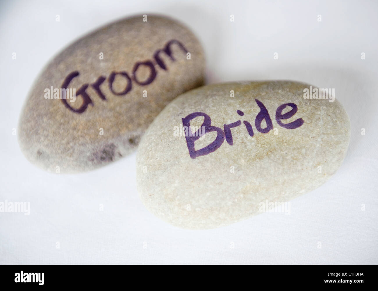 two stones pebbles with bride and groom written on them in marker pen ...